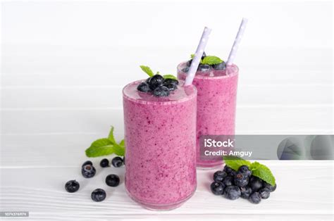 블루베리 스무디 보라색 다채로운 과일 주스 밀크 블렌드 음료 건강 한 고 단백 흰색 나무 바탕에 유리 음료 에피소드 아침에 맛