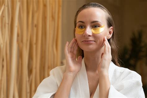 욕실 거울에 서있는 동안 화장품 눈 패치를 적용 목욕 가운을 입고 젊은 여자 가정 생활에 대한 스톡 사진 및 기타 이미지 가정 생활 갈색 머리 거실 Istock