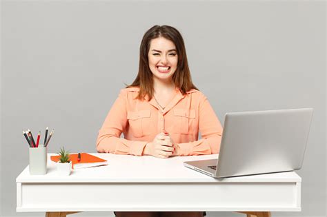 회색 배경에 고립 된 Pc 노트북과 책상에서 작업을 접힌 손으로 파스텔 캐주얼 옷을 들고 젊은 혼란 웃는 여자 성취 비즈니스 커리어 라이프 스타일 컨셉 복사 공간을 모의