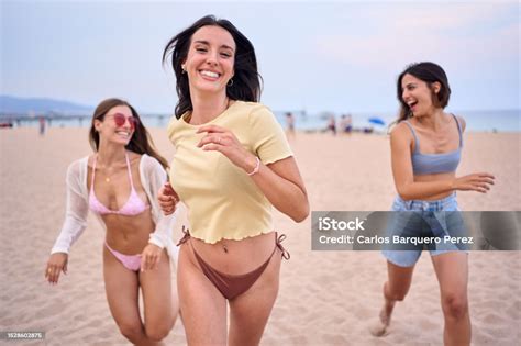 해변을 따라 행복하게 달리는 세 명의 아름다운 젊고 매력적인 여성들의 그룹 여름 방학 20 29세에 대한 스톡 사진 및 기타 이미지 20 29세 3 명 Z세대