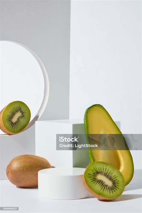 흰색 배경 사진은 신선한 키위와 아보카도의 녹색과 노란색이 다른 모양의 빈 받침대와 함께 눈에 띕니다 디자인 요소와 텍스트를