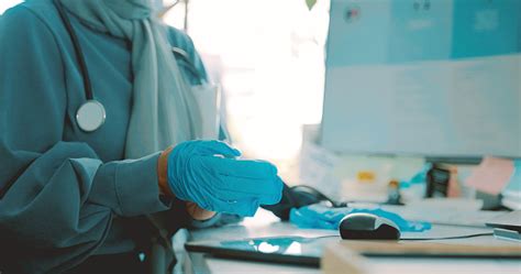 장갑 손 및 건강 관리와 무슬림 의사가 병원에서 손에 장갑을 끼고 있습니다 여성 이슬람 외과 의사가 약속이나 검진을 준비하는 의료 건강 및 의학 45 49세에 대한 스톡