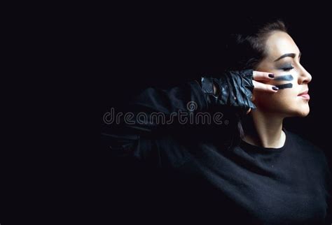 Красивая агрессивная женщина над темной предпосылкой Темный и загадочный милая девушка стоит в