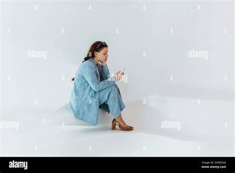 Side View Of Full Body Of Content Female In Elegant Wear Scrolling Social Media On Cellphone