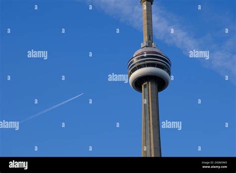 Toronto Cn Tower With Blue Sky And An Airplane In The Background Stock