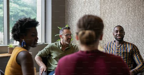 사무실 라운지에 함께 앉아 일에 대해 토론하는 다양한 미소 짓는 사업가 그룹 사진 Unsplash의 성공 이미지