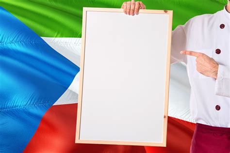 적도 기니 국기 배경에 빈 화이트 보드 메뉴를 들고 요리사 텍스트에 대 한 균일 한 포인팅 공간을 착용 요리 고급 요리에 대한