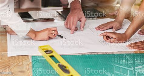 손 청사진 및 건축과 함께 디자인 팀이 평면도를 사용하여 테이블에 계획을 세웁니다 프로젝트 개발 작업 중인 엔지니어 직원 그룹과의 구축 전략 및 협업 평면도에 대한 스톡