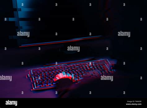 Hacker In The Hood Working With Computer Typing Text In Dark Room Image With Glitch Effect