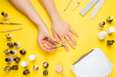 고급 스러운 미용실에서 네일 아트 손톱 모델링을 위한 젤 여성은 미용사에 의해 매니큐어를 받습니다 노란색 배경 관심과 손톱의