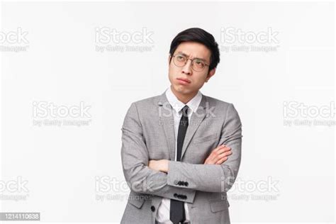 회색 정장에 당황 심각한 찾고 아시아 남자의 허리 업 초상화 찡그린 얼굴을 보고 사려 깊은 크로스 핸즈 가슴 메이크업 솔루션을 시도 선택 우유부단 한 만들기 경영자에 대한