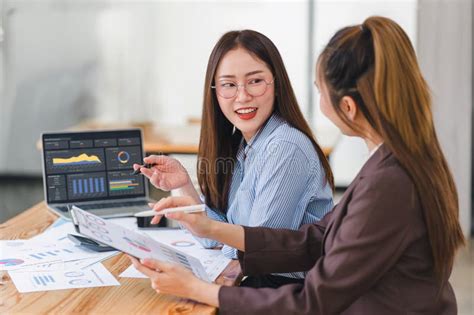 Two Professionals Analyzing Business Data On Dashboard Screen And