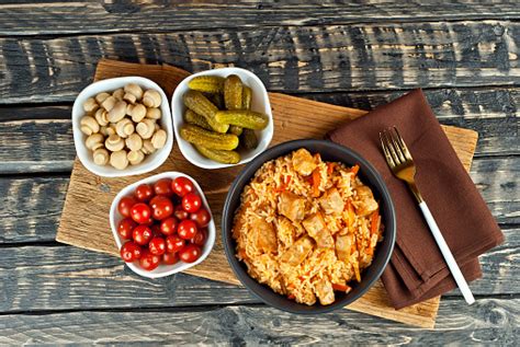 검은 그릇에 고기와 당근을 곁들인 필라프 검은 색 배경에 양념 버섯 토마토와 오이 초라한 테이블에 음식 오래된 나무 판에 그릇 고기에 대한 스톡 사진 및 기타 이미지