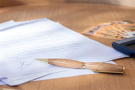 나무 테이블에 있는 선택적 초점과 펜 유로 모네 지폐 및 계산기로 서명된 문서의 보기를 닫습니다 0명에 대한 스톡 사진 및 기타