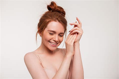 귀여운 미소를 가진 행복하고 아름다운 빨간 머리 여성이 피부와 손 관리를 하고 스튜디오에서 흰색 배경에서 즐거운 시간을 보내고 있습니다 아름다움과 건강 25 29세에 대한