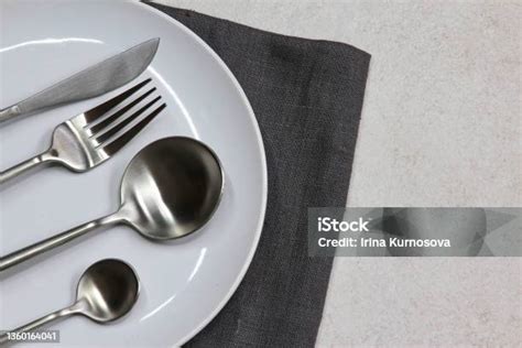 회색 돌 배경에 어두운 직물 냅킨과 칼 숟가락과 포크흰색 빈 접시 테이블 설정입니다 맨 위 보기입니다 0명에 대한 스톡 사진 및