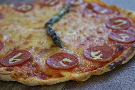 페 퍼 니 조각 모 짜 렐 라 치즈와 아스파라거스에 숫자를 가진 수 제 피자 시계의 이미지 시간을 말하는 시계 바늘 1700 5 시 이탈리아 피자 레스토랑에서 어린이 생일