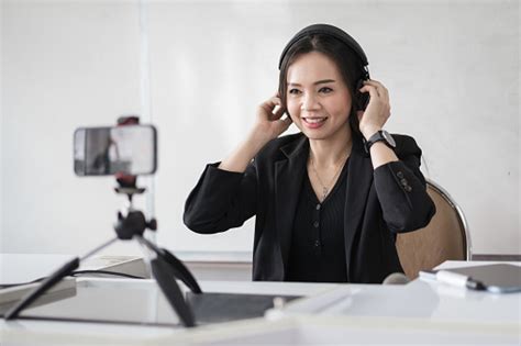 성인 아시아 여성 대학 교사는 집에서 학생들에게 화상 회의 회의를 통해 온라인으로 가르치고 학생들과 화상 통화를 하는 아시아
