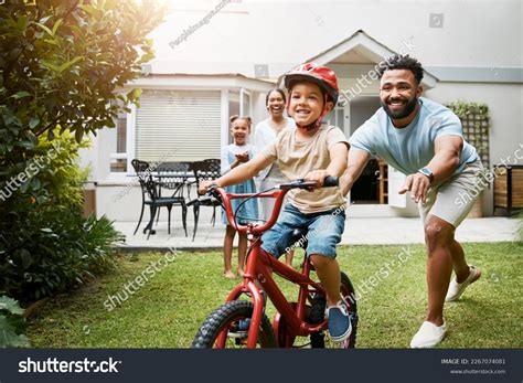 Learning Bicycle And Proud Dad Teaching His Young Son To Ride While