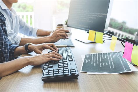 소프트웨어 개발 회사 사무실에서 작업하는 프로그래밍 및 웹 사이트 개발에 협력하는 두 명의 전문 프로그래머 코드 작성 및 데이터 코드 입력 개발에 대한 스톡 사진 및 기타