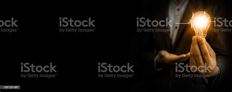 주황색 불빛이 달린 전구를 들고 있는 남자 전구를 들고 있는 양복을 입은 사업가의 초상화 남성 사업가 배경 이미지 및 비즈니스 성장 복사 공간이 있는 배너 배경입니다 개발에