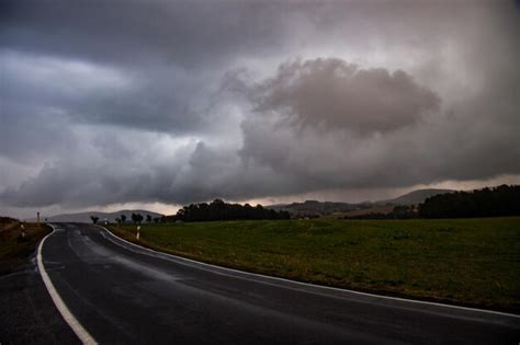 Premium Photo Road Passing Through Landscape Against Storm Clouds