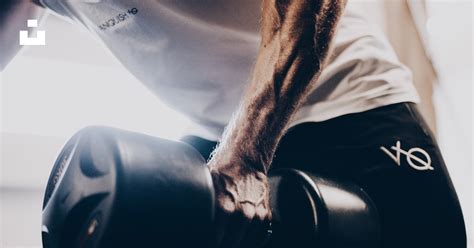 파란색 탱크탑과 검은색 반바지를 입은 남자가 검은 덤벨을 들고 있다 사진 Unsplash의 무료 강한 남자 이미지