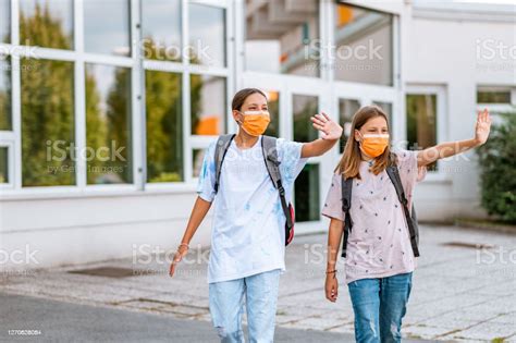 학교 앞에서 흔들리는 보호 얼굴 마스크를 가진 두 명의 어린 여학생 10 11세에 대한 스톡 사진 및 기타 이미지 10 11세 12 13세 2명 Istock