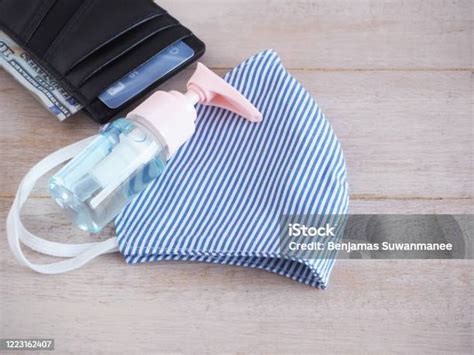 흰색과 파란색 줄무늬 직물 얼굴 마스크오염 및 바이러스를 방지하기 위해 병에 알코올 젤면 모슬린에서 손으로 만든 Diy 와 흰색 나무 배경에 돈 클립 헬스케어와 새로운 정상