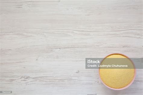 흰색 나무 배경 머리 위 보기 위에 분홍색 그릇에 건조 세몰리나 듀럼 밀가루 상단보기 위에서 평평한 누워 공간을 복사합니다 가득