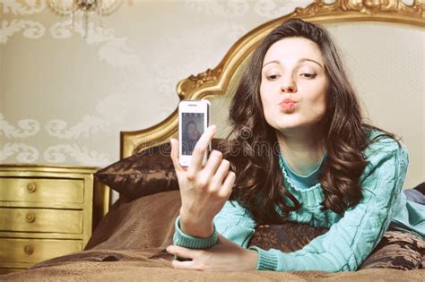 Mulher Moreno Nova Bonita Na Cama Que Sorri Tomando Um Selfie Foto De