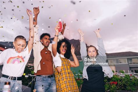 떨어지는 색종이 아래에서 응원하는 네 명의 행복한 친구 20 29세에 대한 스톡 사진 및 기타 이미지 20 29세 Z세대