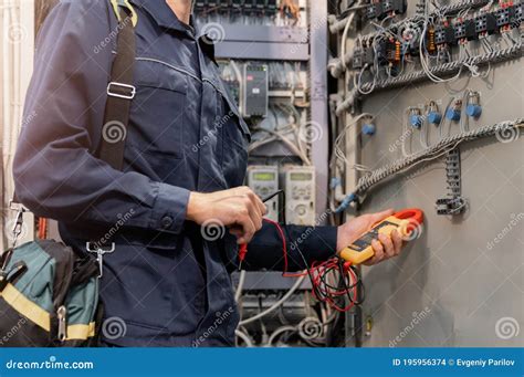 Electrician Engineer Checks Electrical Circuit In Control Panel For