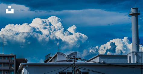 굴뚝이 있는 건물과 구름이 있는 푸른 하늘 사진 Unsplash의 무료 자연 이미지