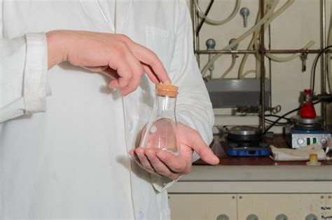 Premium Photo A Flask In The Hands Of A Laboratory Assistant Closeup