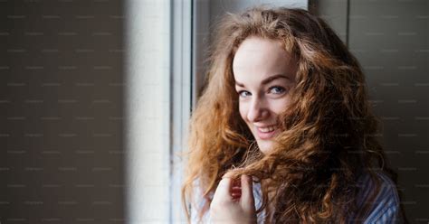 집에서 실내 창가에 서 있는 젊은 여성의 클로즈업 초상화 공간을 복사합니다 사진 Unsplash의 머리 이미지