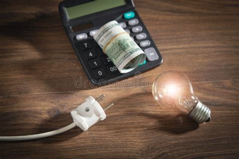 Dollar Banknote Light Bulb Calculator Electric Plug On The Wooden