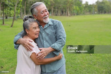 행복한 아시아 노인 남자와 여자가 야외 정원에서 피크닉 바구니를 들고 서서 포옹하고 있다 공원에서 피크닉을 가는 연인 커플 행복 결혼 생활 방식 개념 2명에 대한 스톡 사진