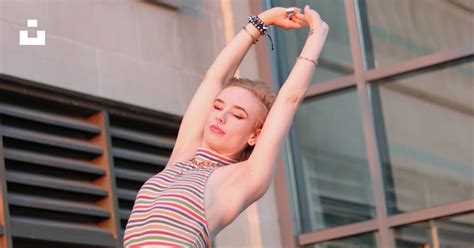 빨간색과 흰색 줄무늬 탱크 탑과 흑백 줄무늬 바지를 입은 여자 그녀를 키우고 사진 Unsplash의 무료 자유 이미지