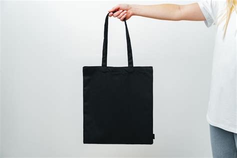 흰색 배경에 에코 또는 재사용 가능한 쇼핑백을 들고 있는 여성 손 프리미엄 사진