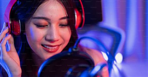 아시아의 매력적인 오디오 Dj 여성이 방송에 마이크에 대고 말한다 젊은 아름다운 여성 블로거 인플루언서가 헤드폰을 착용하고 홈 스튜디오에서 라디오를 위한 아침 뉴스