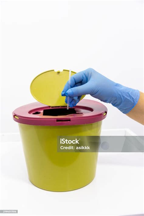 의료 쓰레기통 병원의 유해 폐기물 용기 의료 폐기물과 사용한 주사기는 쓰레기통에 버리십시오 의사가 흰색 배경에 날카로운 물건 용기에 사용한 주사기를 던지고 있습니다 0명에