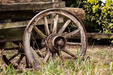 Premium Photo A Wooden Wagon Wheel Is In The Grass