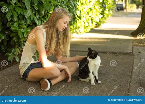 Ragazza Teenager Che Si Siede Con Un Gatto Sul Marciapiede Immagine Stock Immagine Di Stile