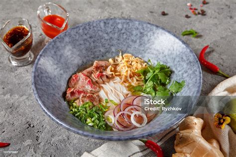 베트남 요리 쇠고기 포 국수 수프 또는 포 보 수프 텍스처 다크 그레이 테이블에 블루 볼에 신선한 채소와 함께 제공됩니다 매운 소스를 곁들인 포보 수프 건강한 식생활에 대한