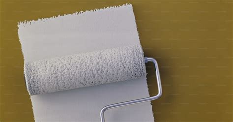 노란색 벽 위에 하얀 페인트 뭉치가 놓여 있다 사진 Unsplash의 페인트 롤러 이미지