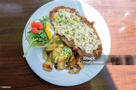 치즈 소스를 곁들인 브레드 슈니첼 흰 접시에 감자 튀김 샐러드 갈색 나무 테이블 위에서 높은 각도의 전망 엄선된 초점 슈니첼에 대한 스톡 사진 및 기타 이미지 Istock