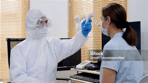 바이러스 감염 여성 환자의 건강을 확인하기위한 적외선 온도계를 사용하여 얼굴 마스크와 안경을 착용 보호 Ppe 정장에 아시아 의사 2명에 대한 스톡 사진 및 기타 이미지