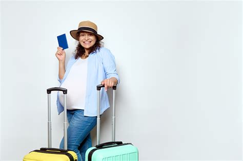 밀짚모자를 쓴 행복한 긍정적인 임산부 여행 가방과 탑승권을 들고 포즈를 취하고 하얀 배경 위에 고립되어 있다 40주 태아에 대한 스톡 사진 및 기타 이미지 Istock