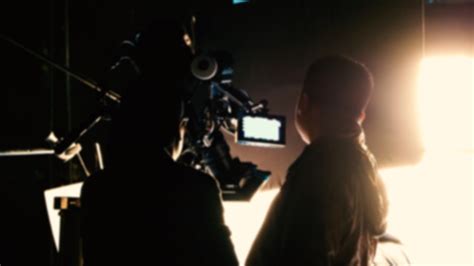 스튜디오에서 전문 장비 카메라 및 조명으로 비디오 제작을 위해 무대 뒤에서 작업하는 실루엣의 인물 영화 제작진의 흐릿한 이미지 2명에 대한 스톡 사진 및 기타 이미지